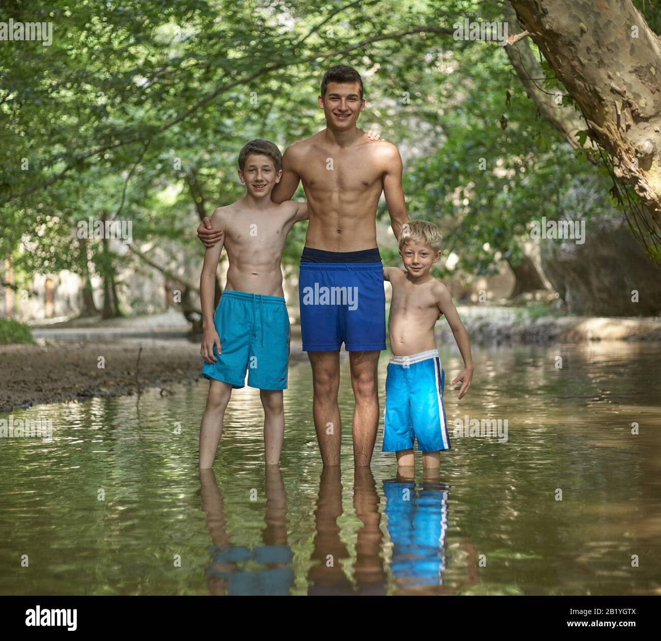 Three happily smiling handsome brothers embracing each other, love ...