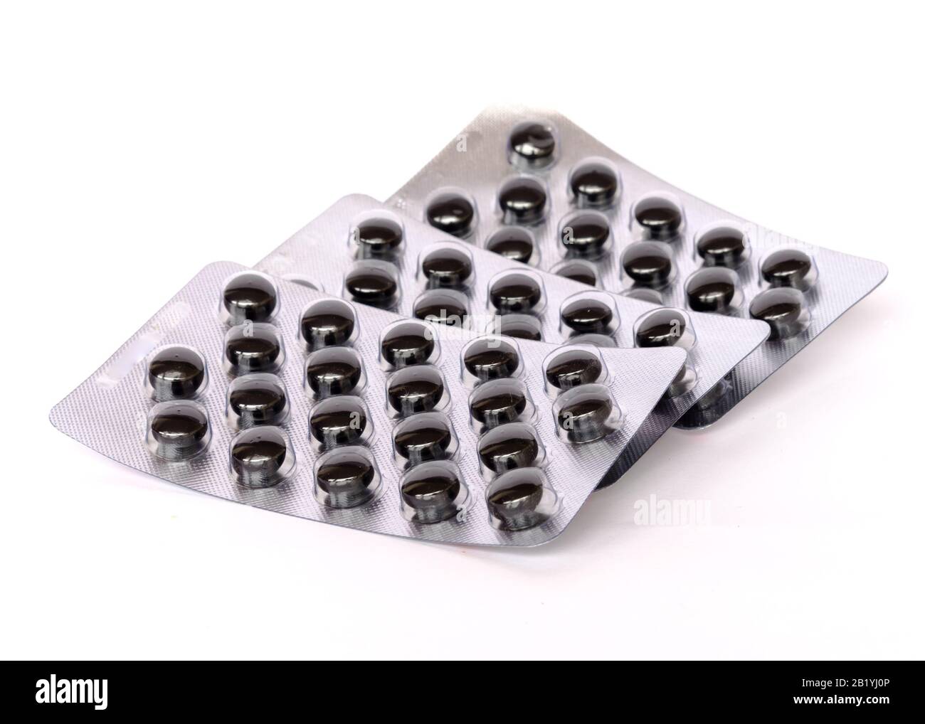 Stack of blister pack contains many black tablets isolated on white ...