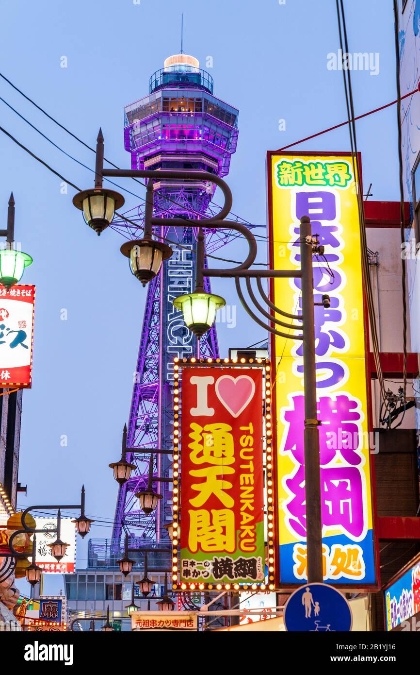 Shinsekai, Osaka during the evening. The lit-up Tsutenkaku tower in the ...