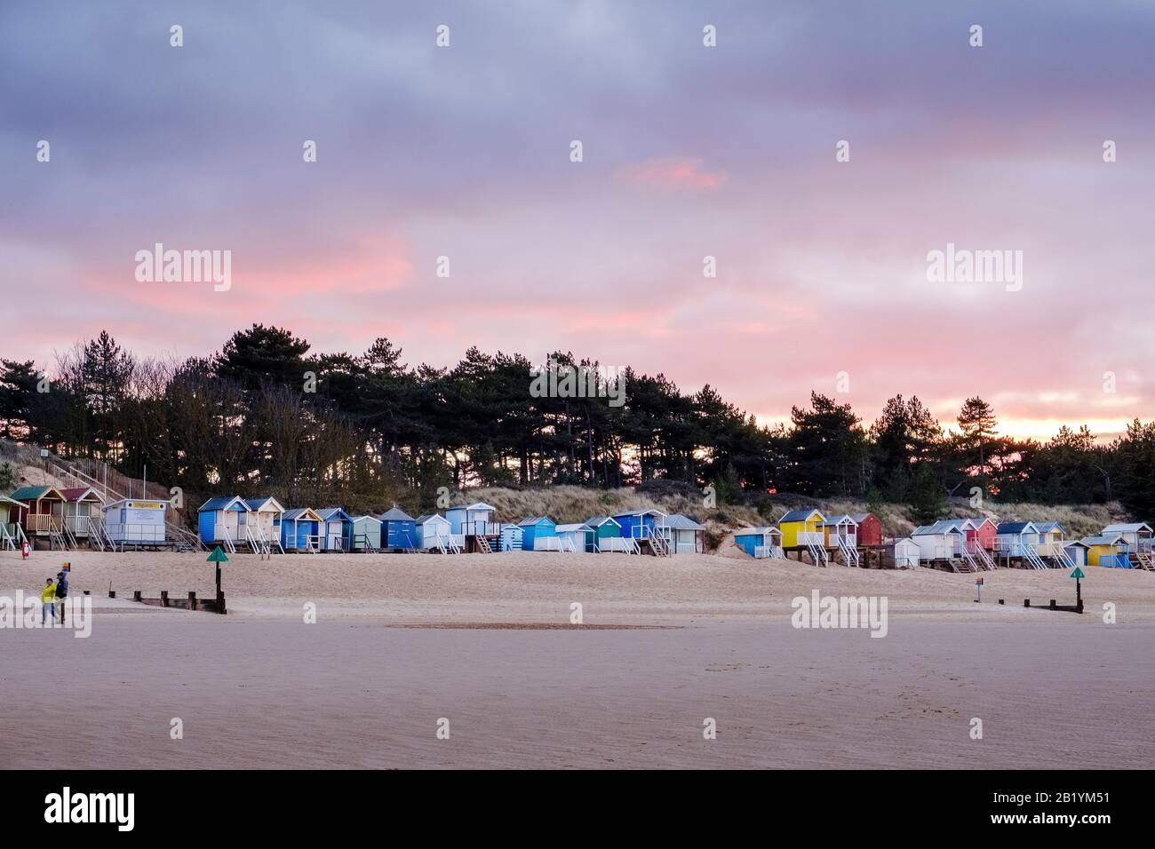 The iconic, brightly coloured beach huts on Wells beach, at sunset in ...