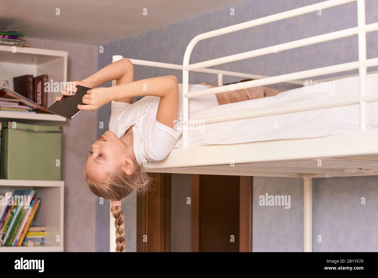 Girl playing with tablet. Not usial use equipment Stock Photo - Alamy