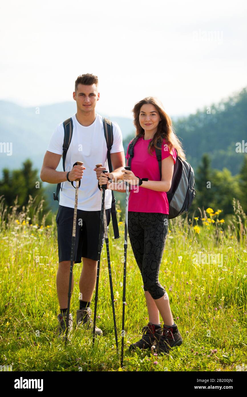 active Beautiful young couple hiking ina nature climbing hill or ...