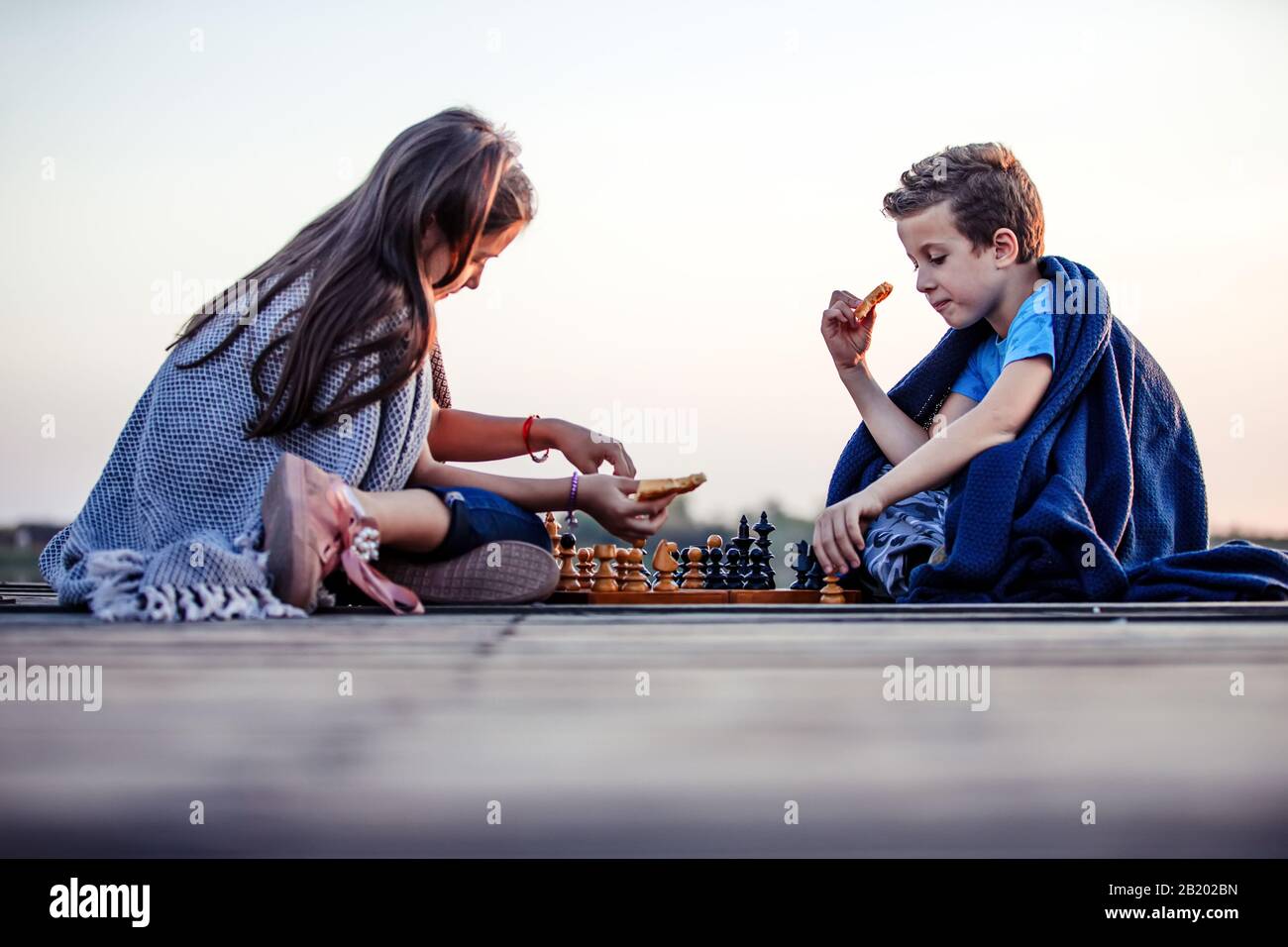 Two young cute little friends, boy and girl having fun while playing ...