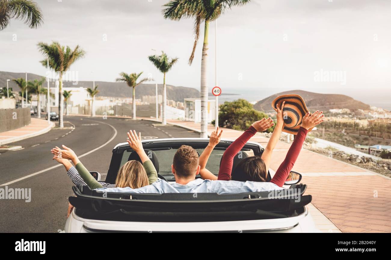 Happy friends having fun in convertible car on vacation - Young ...