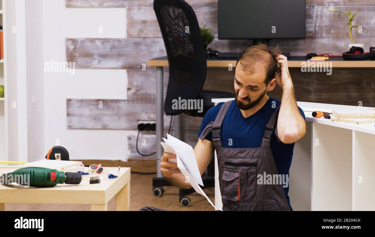 Confused male worker assembling shelf hi-res stock photography and ...