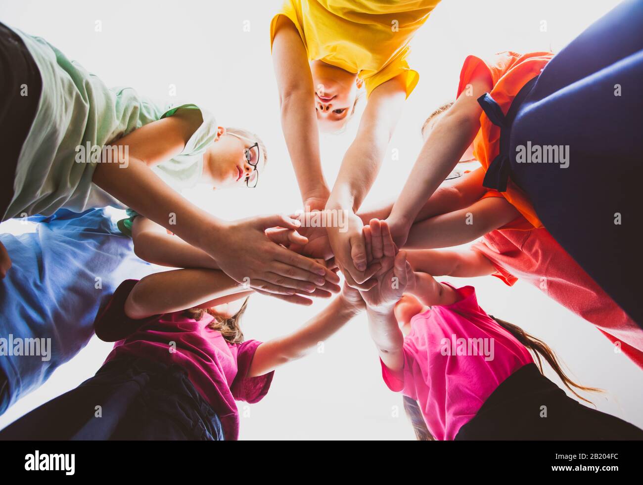 Many children stacking hands together. Symbol for teamwork and ...