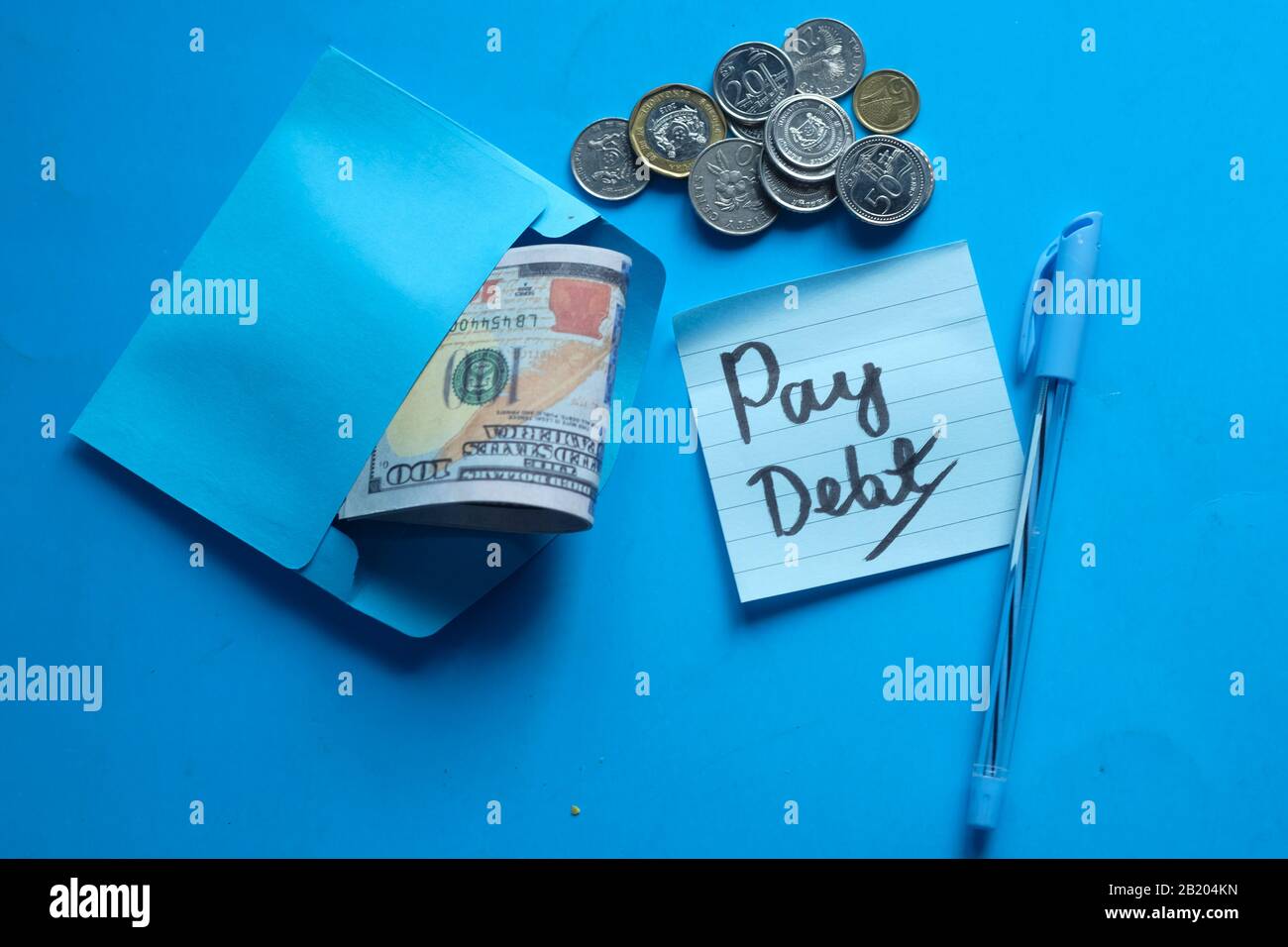 pay debt concept with cash and coin Stock Photo - Alamy