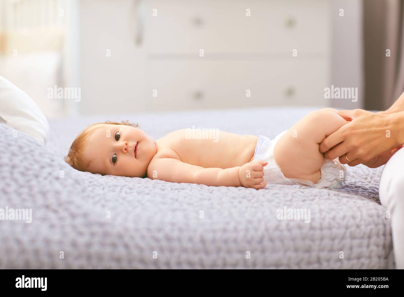 Mother's hands hold the baby by the legs Stock Photo - Alamy