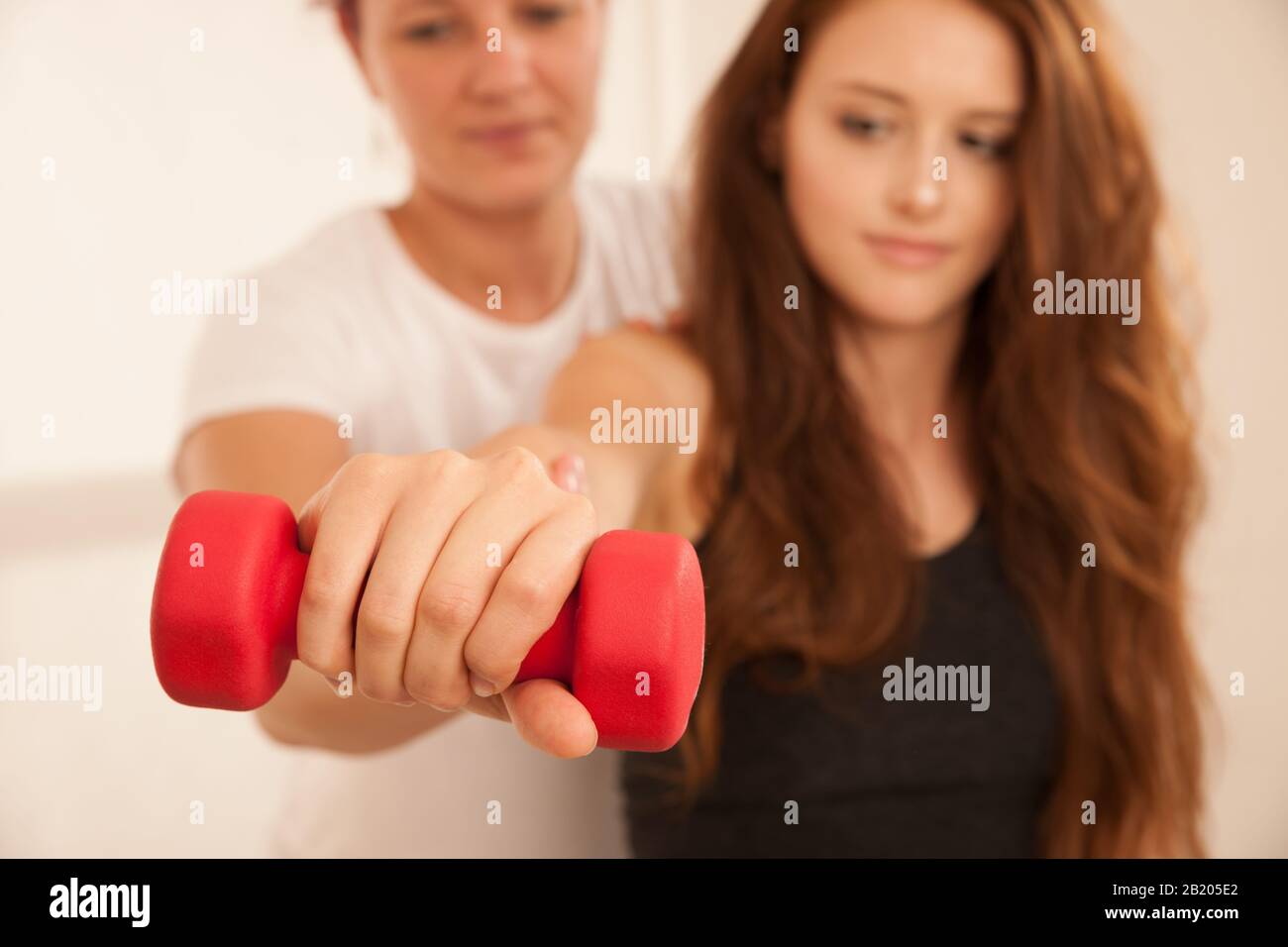 Physiotherapy - young woman making arm exercises with therapist for ...