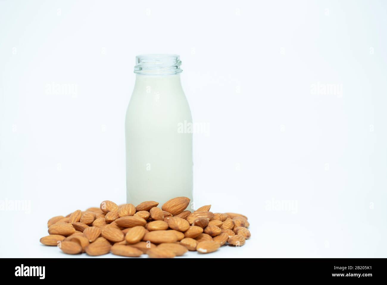 Bottle of almond milk and nuts on white background Stock Photo - Alamy