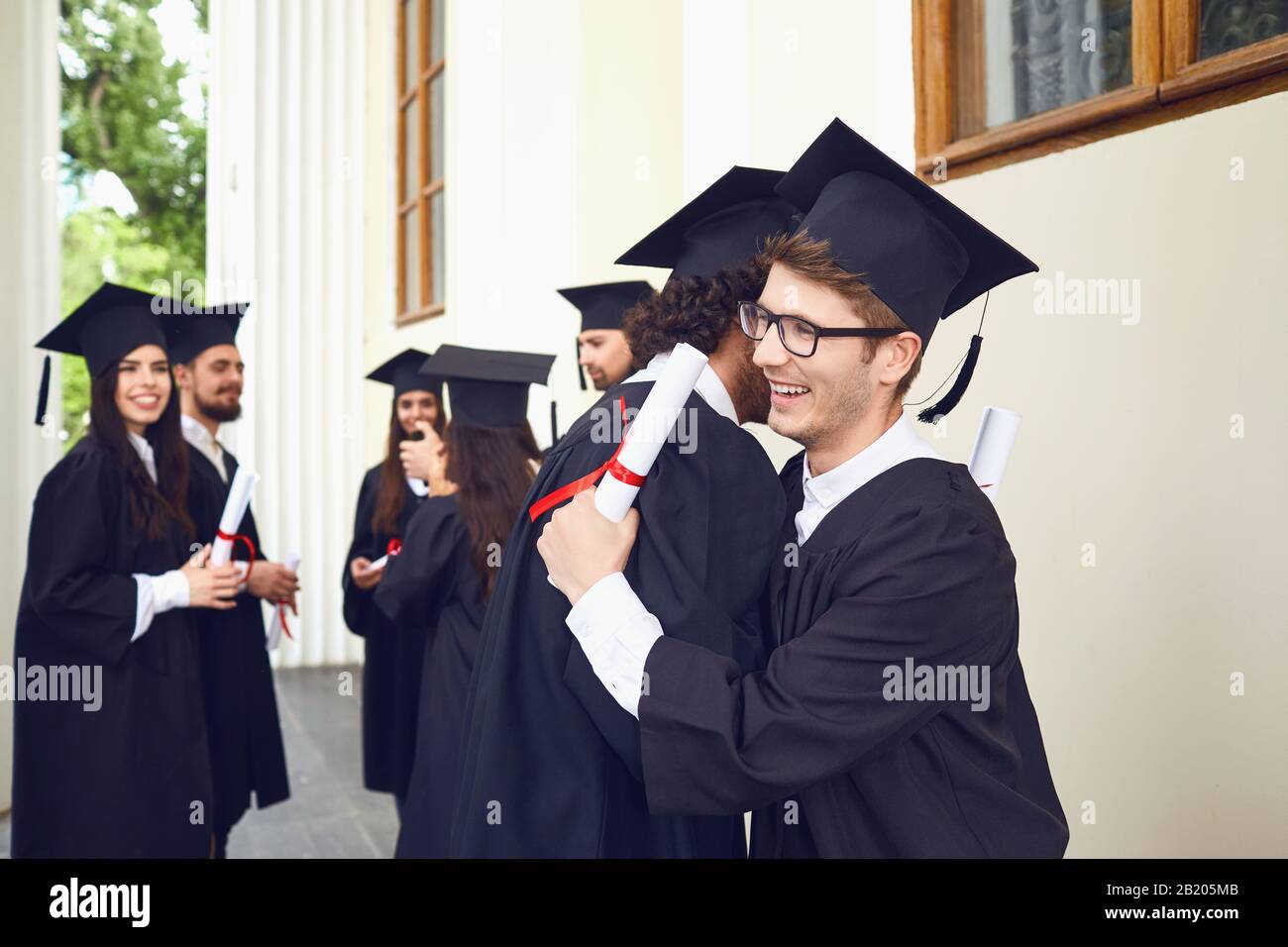 Female graduates with diplomas in their hands hugging Stock Photo - Alamy