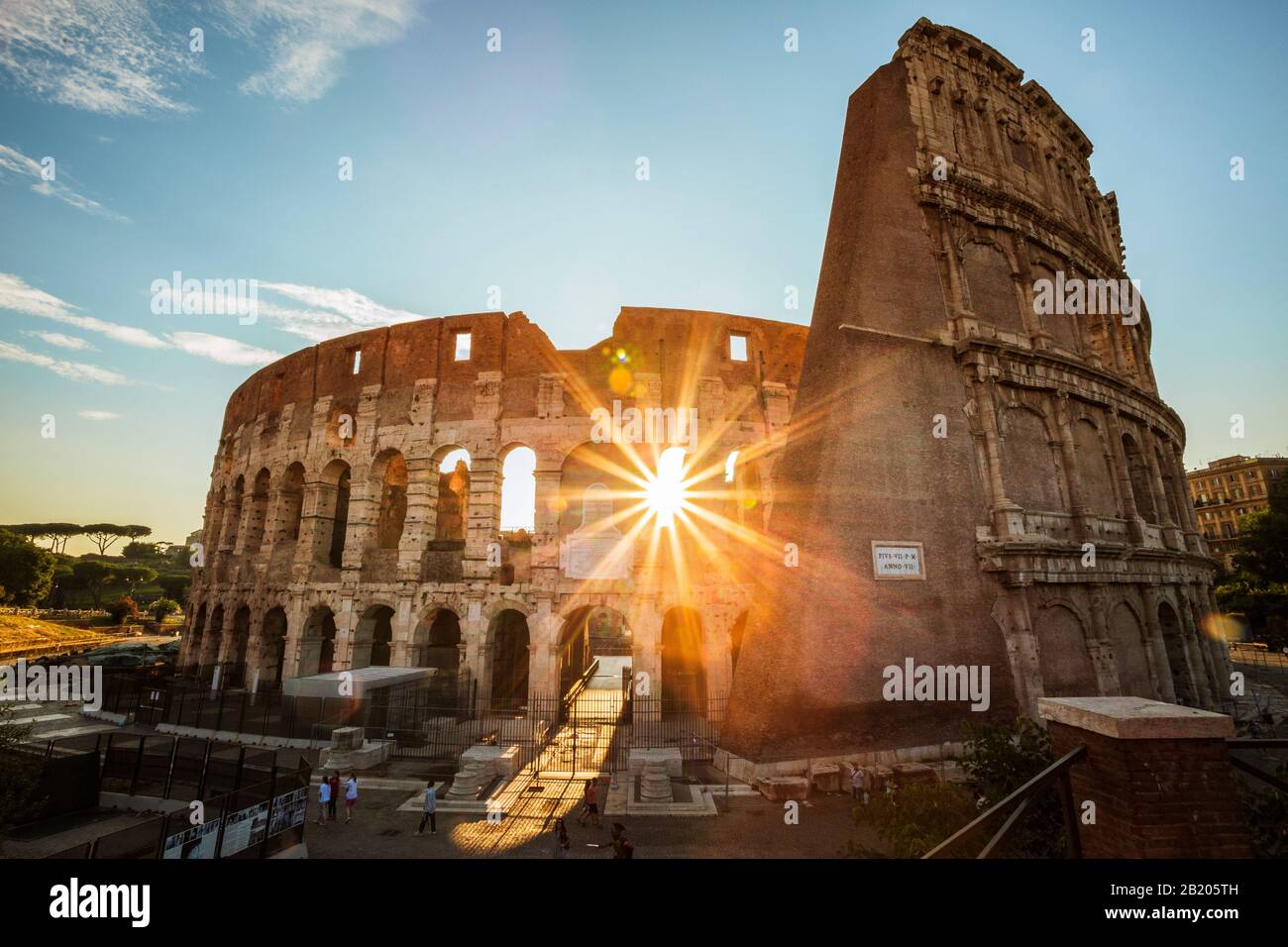 The Colosseum during sunset with sunrays passing throught its columns ...