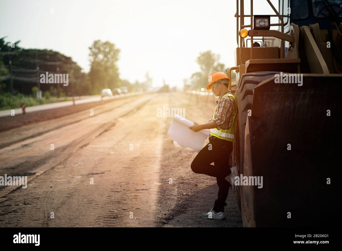 Engineer holding blueprint at construction site Stock Photo - Alamy