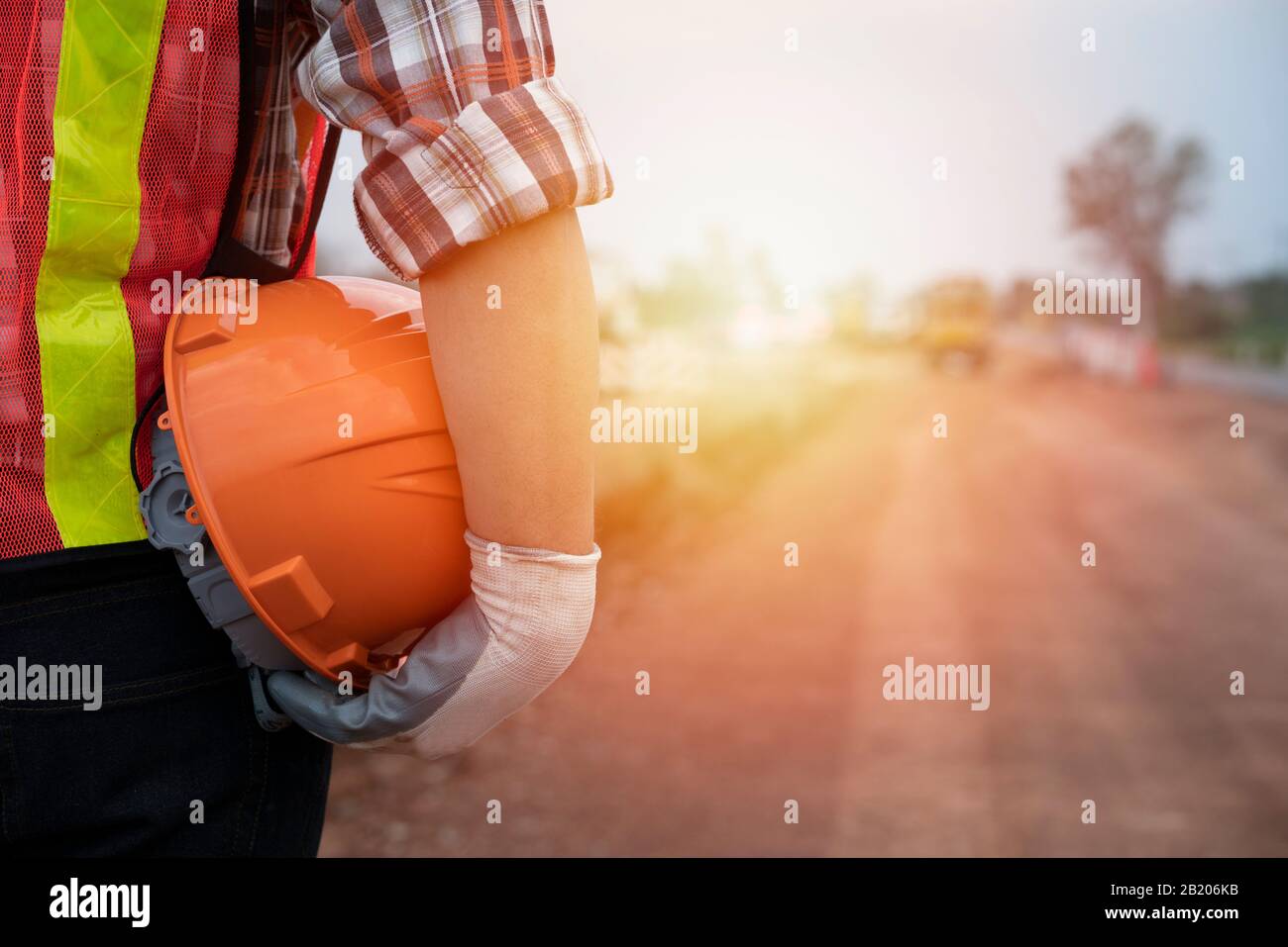 Engineer holding helmet at construction site Stock Photo - Alamy