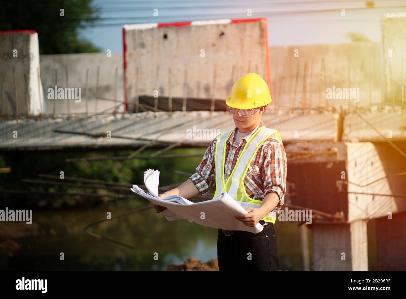 Engineer holding blueprint in construction site Stock Photo - Alamy