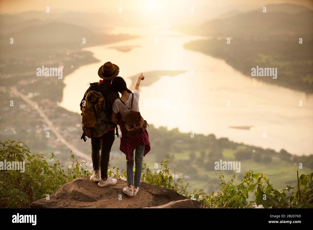 couple backpacker standing on cliff with sunset background Stock Photo ...