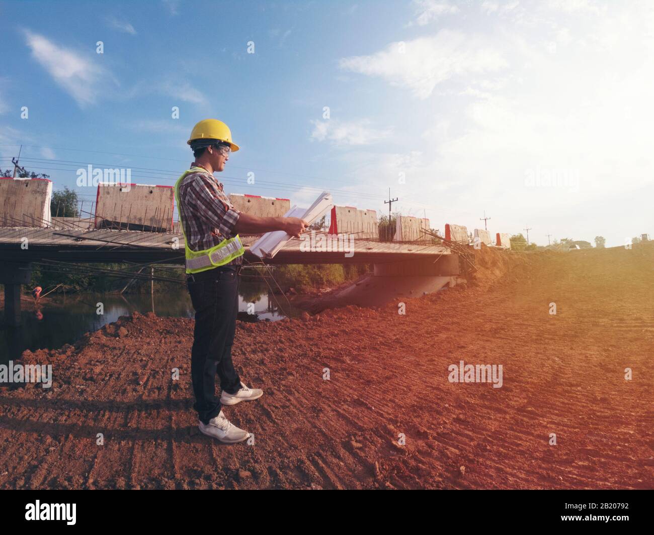 Engineer holding blueprint in construction site Stock Photo - Alamy