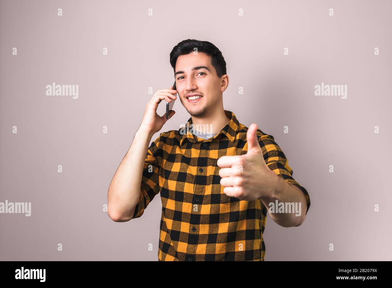 satisfied client. man speaking on the phone showing big thumb up Stock ...