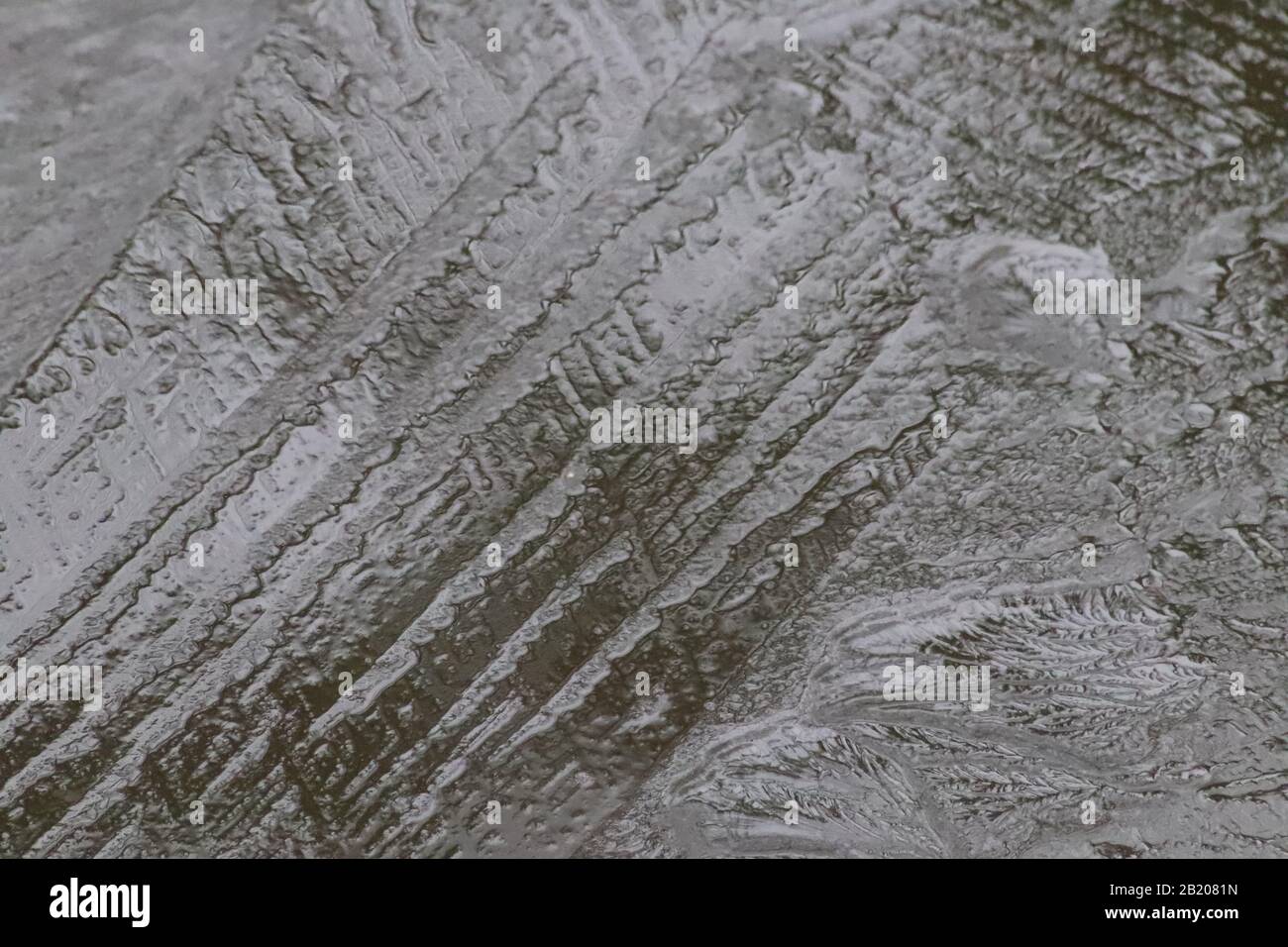 Patterns in ice on frozen pond Stock Photo - Alamy
