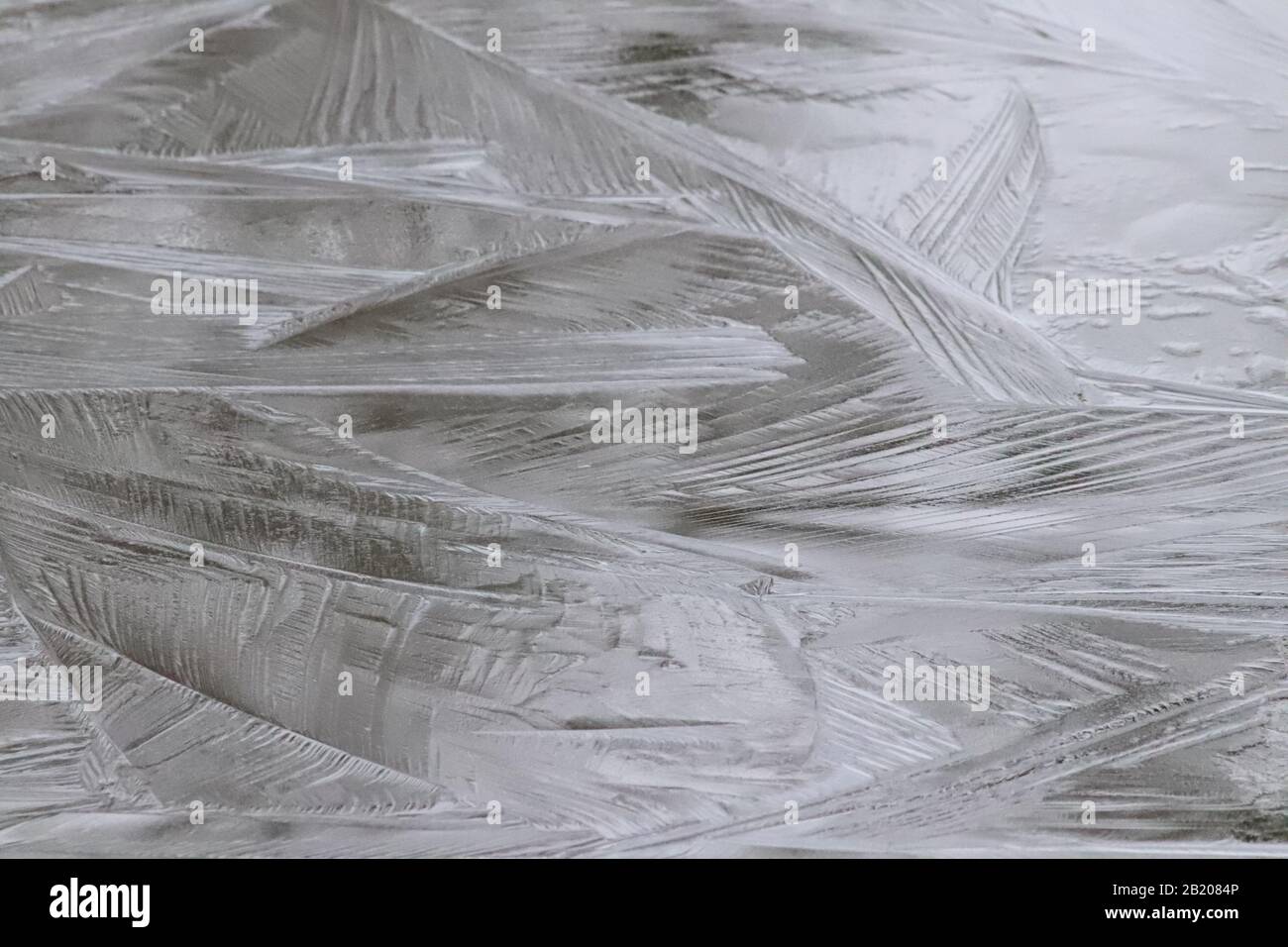 Patterns in ice on frozen pond Stock Photo - Alamy