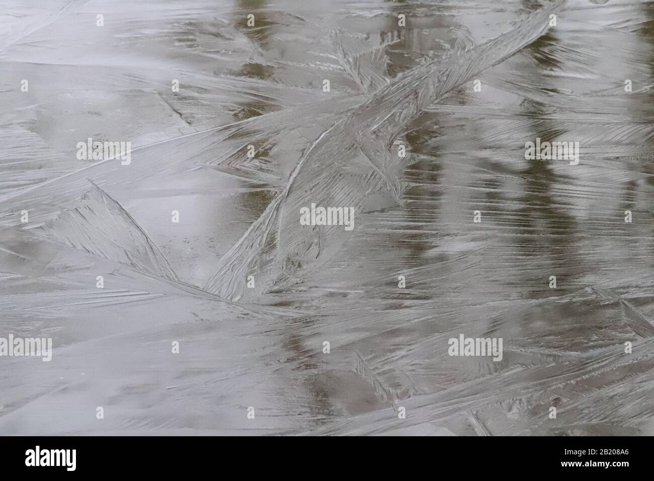 Ice patterns in frozen pond Stock Photo - Alamy