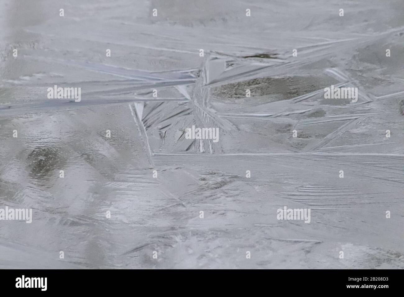 Ice patterns in frozen pond Stock Photo - Alamy