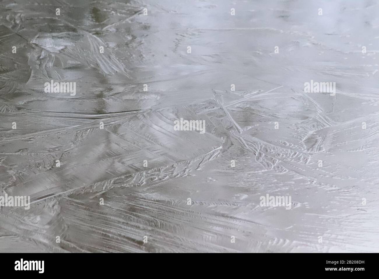Ice patterns in frozen pond Stock Photo - Alamy