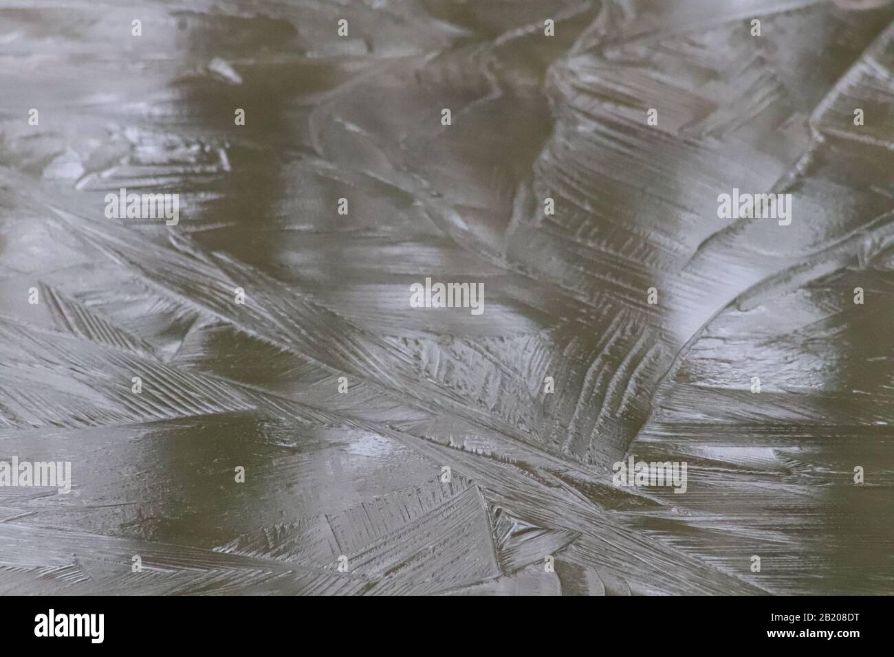 Ice patterns in frozen pond Stock Photo - Alamy