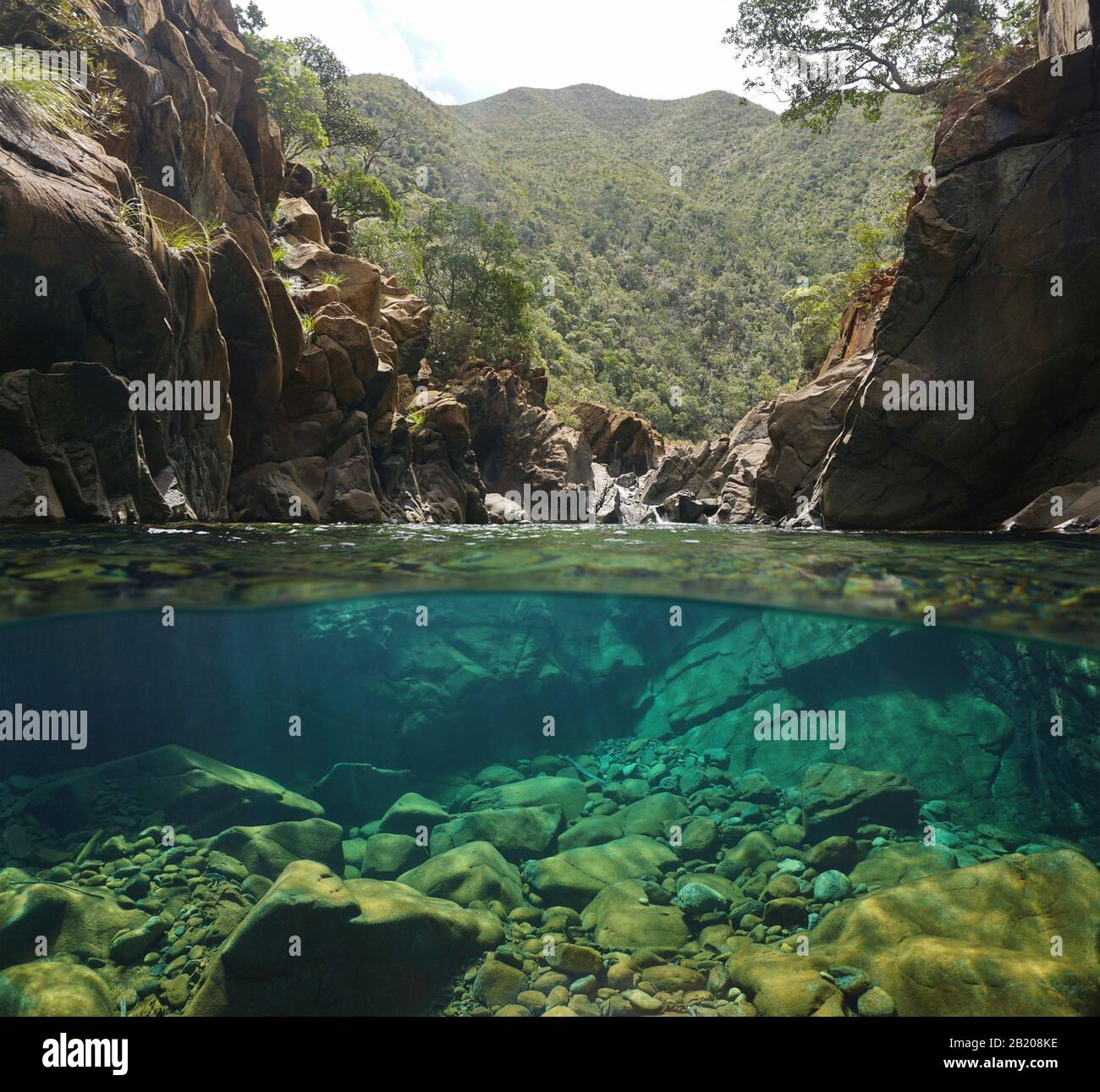 Rocky river with clear water, split view over and under water surface ...
