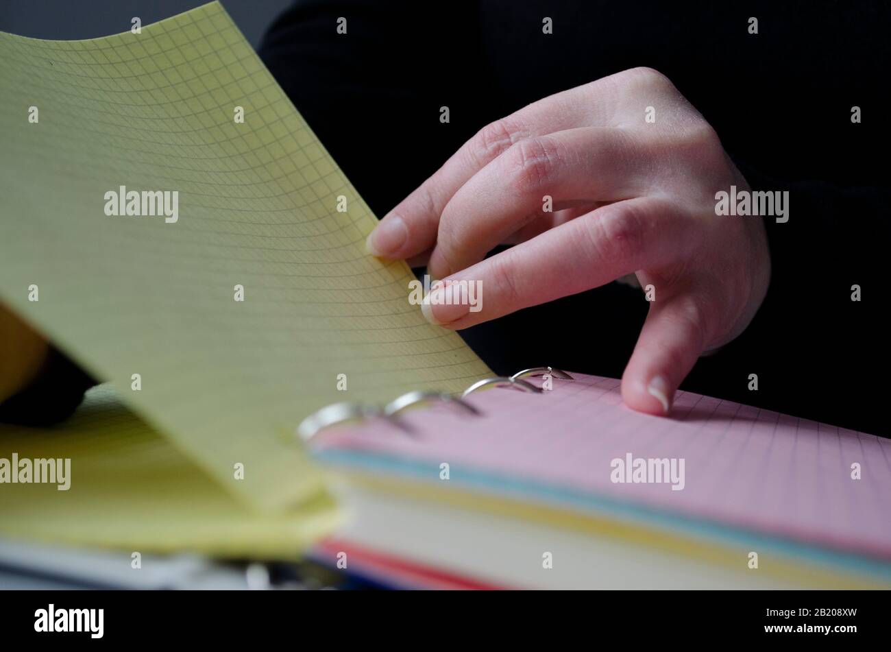 A person reading books near the window. Hands turns over book page ...
