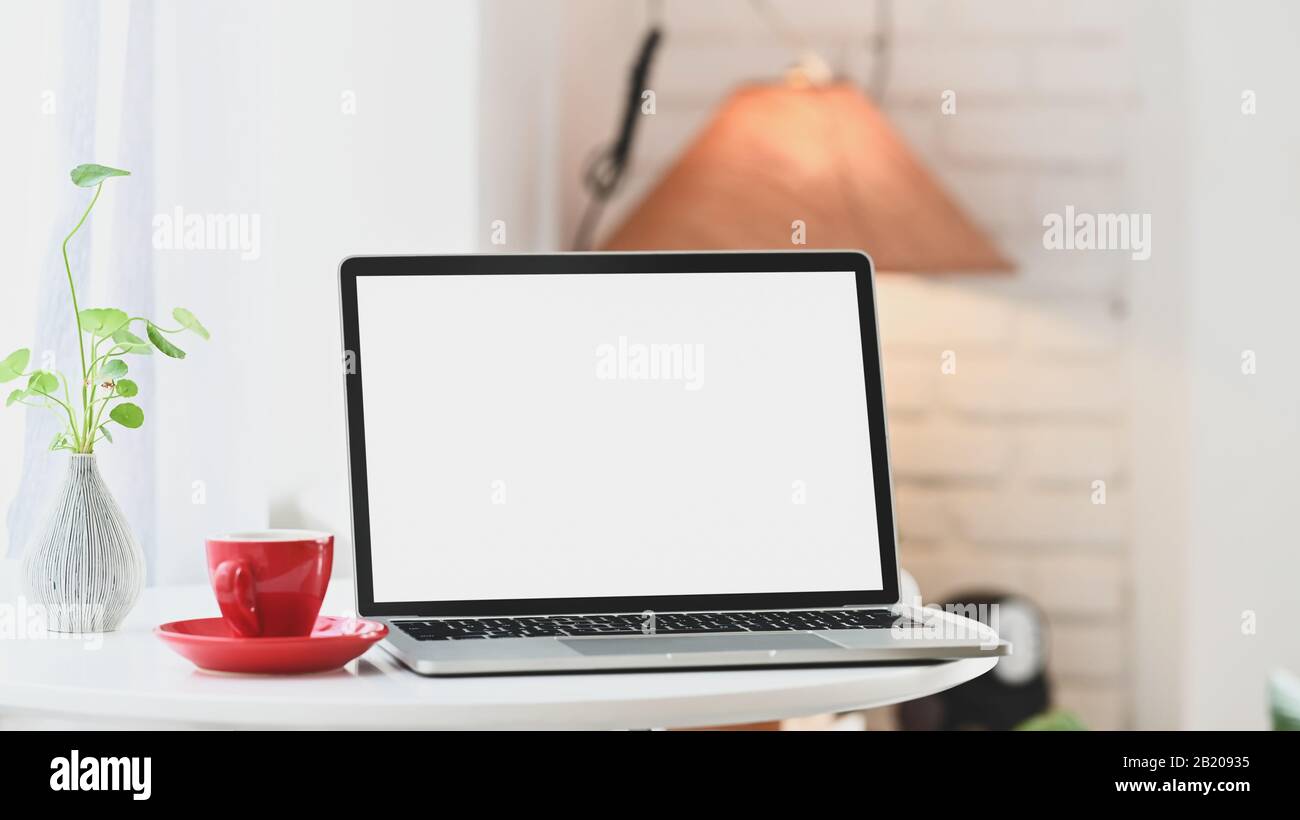 Computer laptop with white blank screen putting together with potted ...
