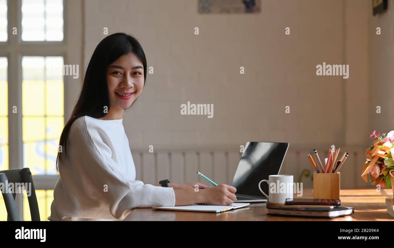 Beautiful writer sitting at the working table and writing her new ...