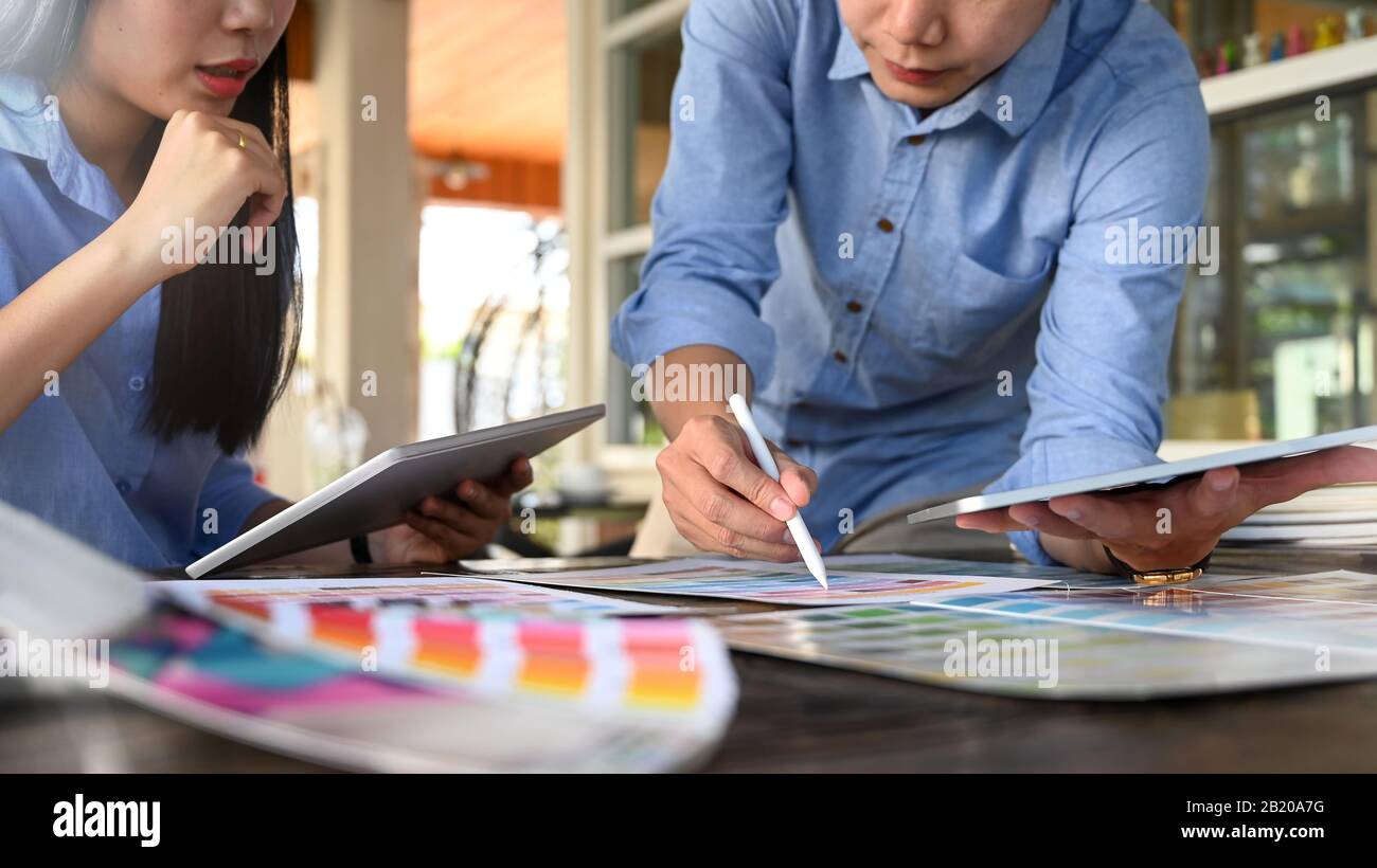 Cropped image of young graphic designer team holding/using a stylus pen ...