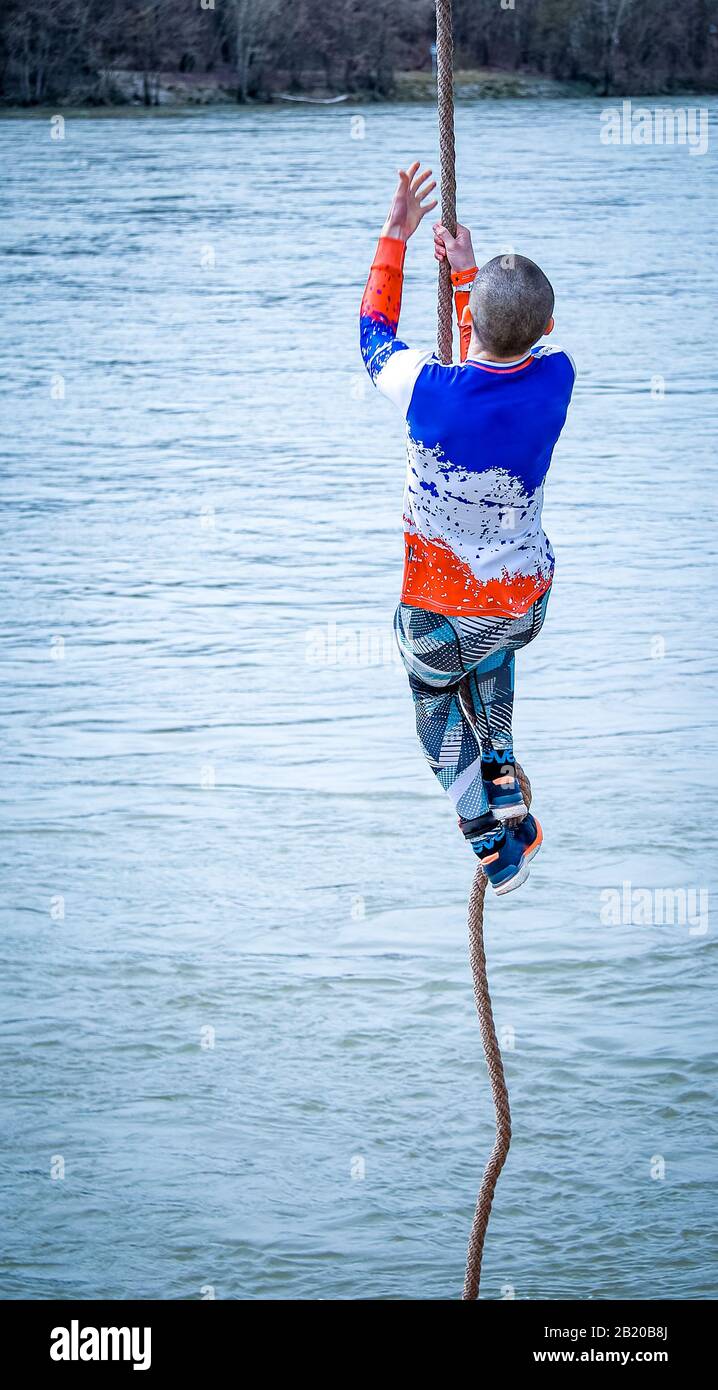 Runner climbing an obstacle during race Stock Photo - Alamy