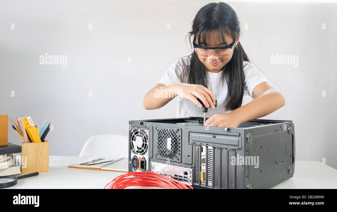 Photo of young adorable girl fixing/installing a computer hardware at ...