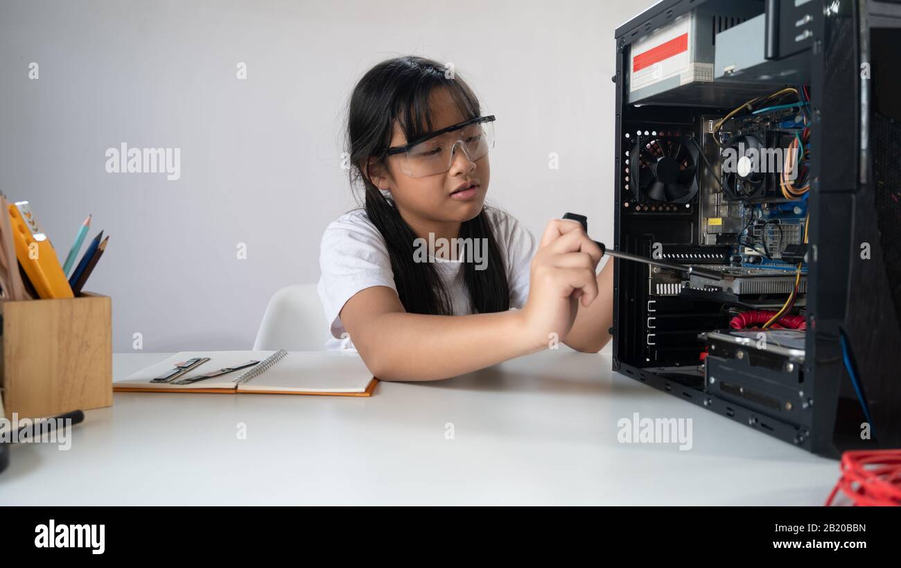 Photo of young adorable girl fixing/installing a computer hardware at ...