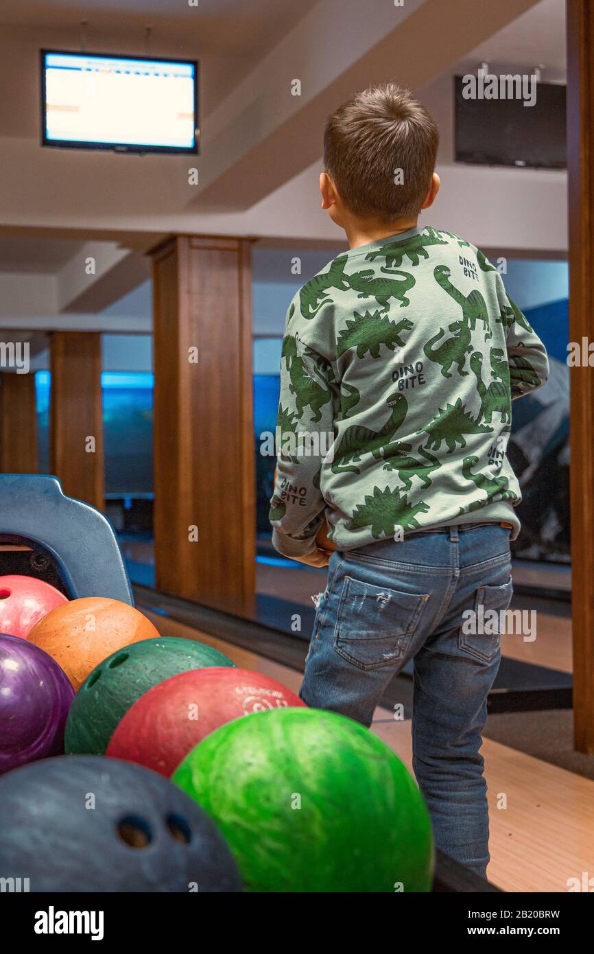 Young boy preparing to throw bowling ball at pins Stock Photo - Alamy