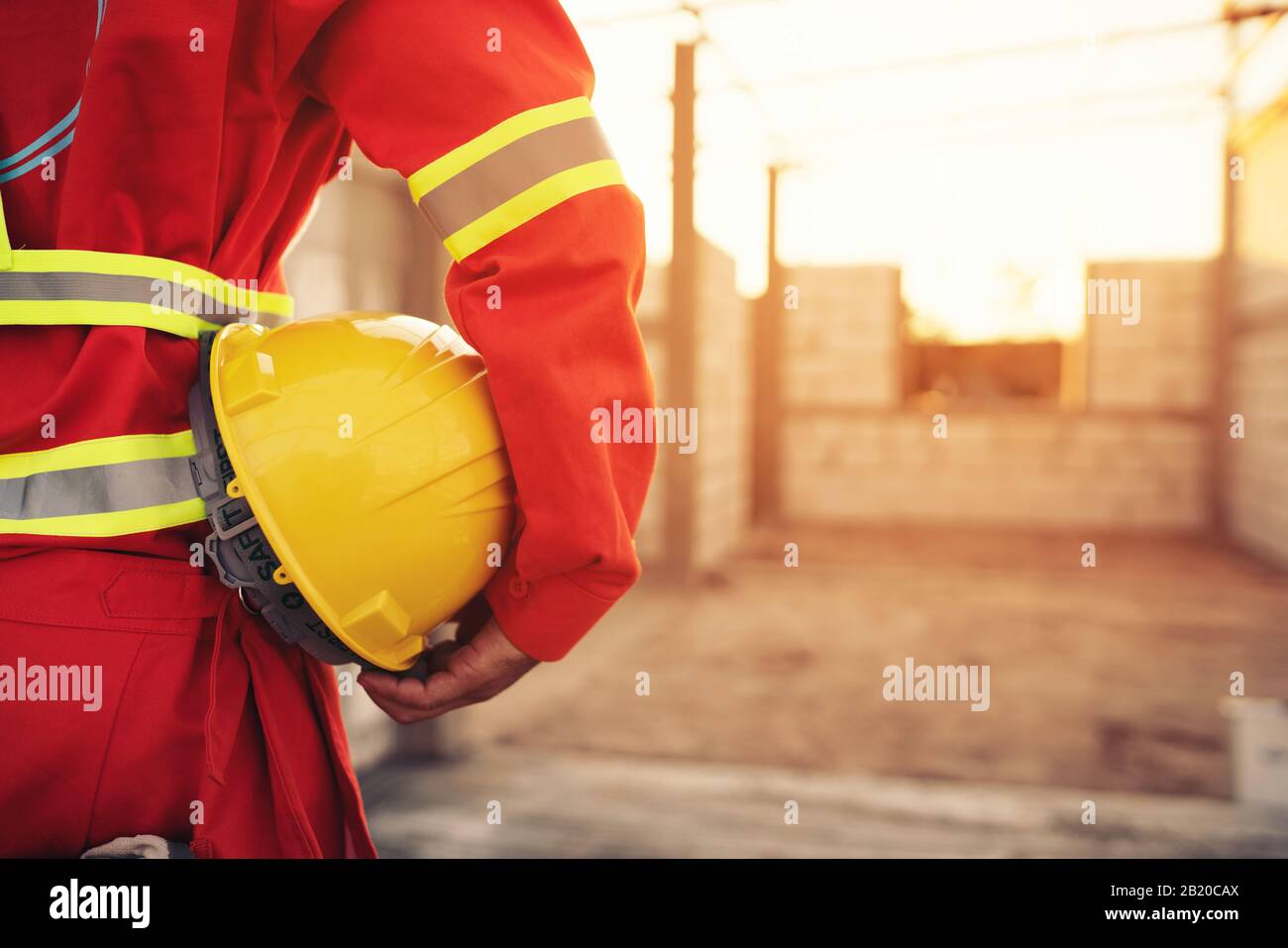 Engineer holding helmet at construction site Stock Photo - Alamy