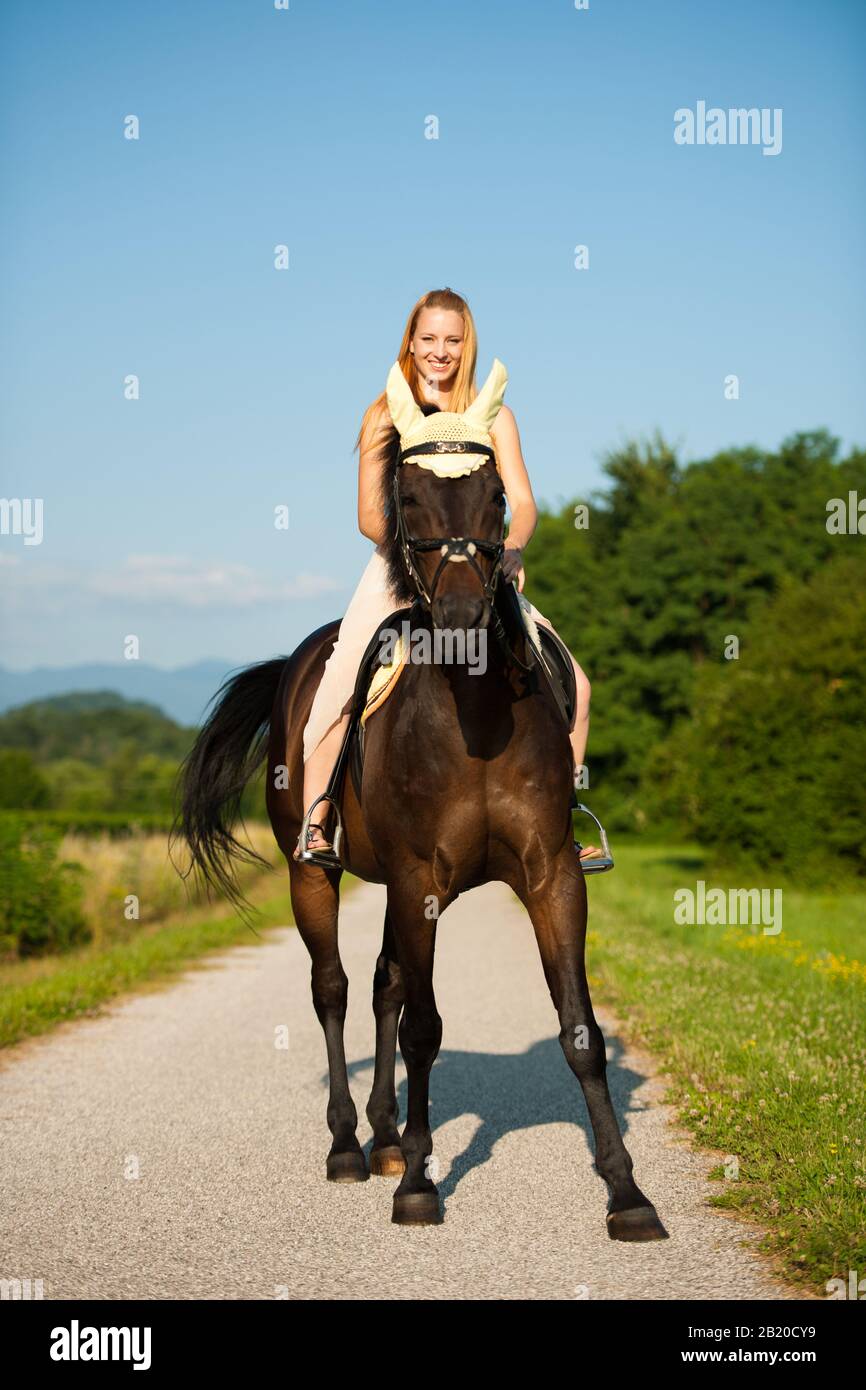 Active young woman ride a horse in nature Stock Photo - Alamy