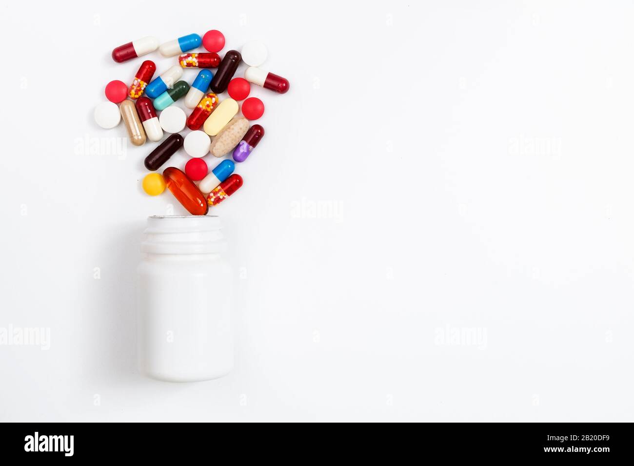 medical drug pouring from bottle on white background Stock Photo - Alamy