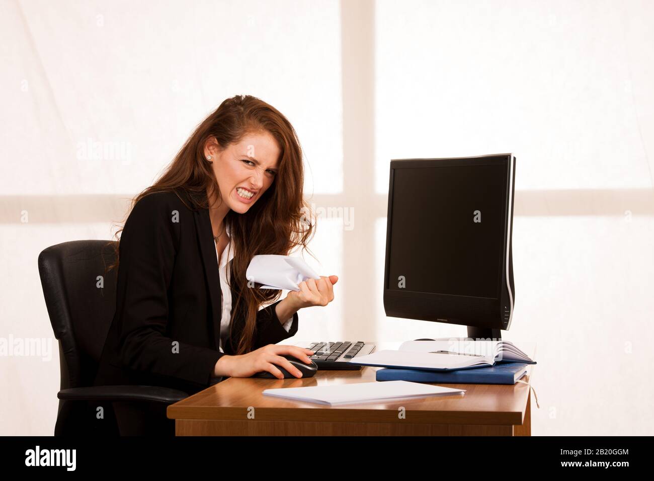Angry business woman expressing rage at her desk in the office Stock ...