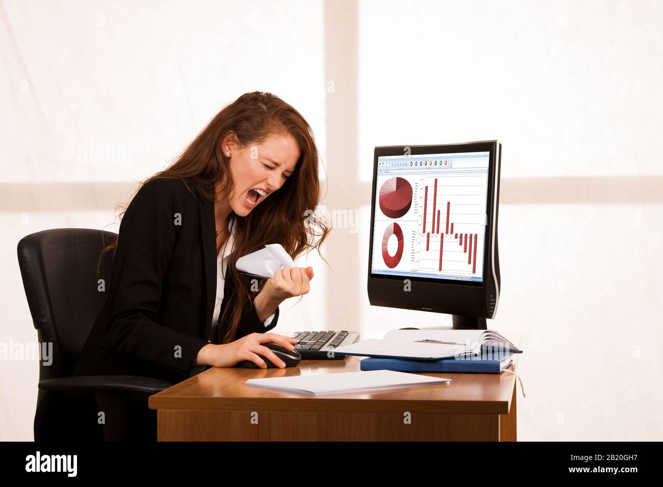 Angry business woman expressing rage at her desk in the office Stock ...