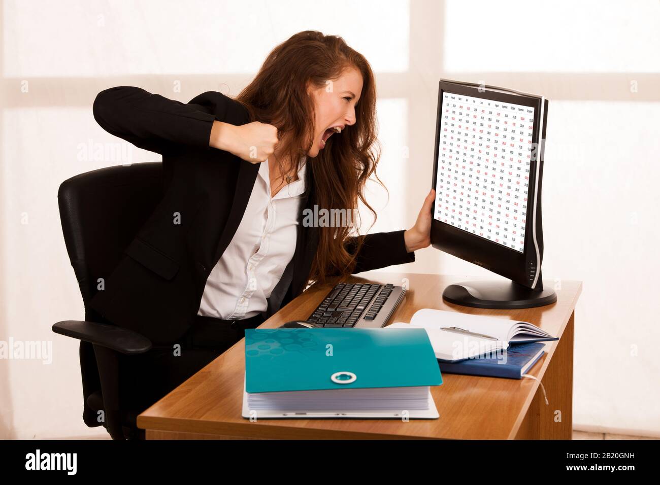 Angry business woman expressing rage at her desk in the office Stock ...
