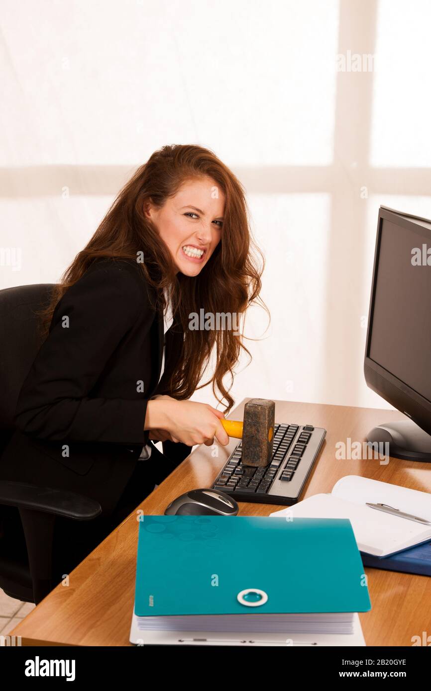 Angry business woman expressing rage at her desk in the office Stock ...