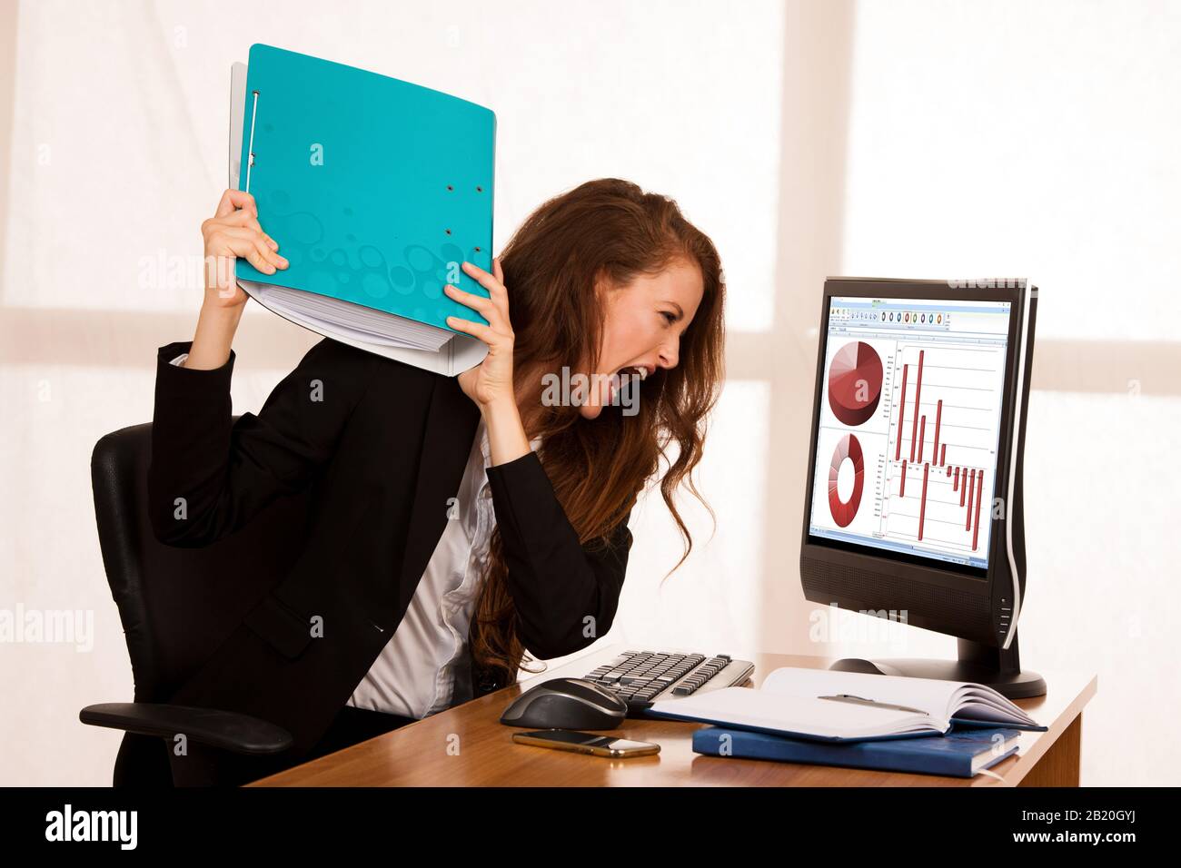 Angry business woman expressing rage at her desk in the office Stock ...