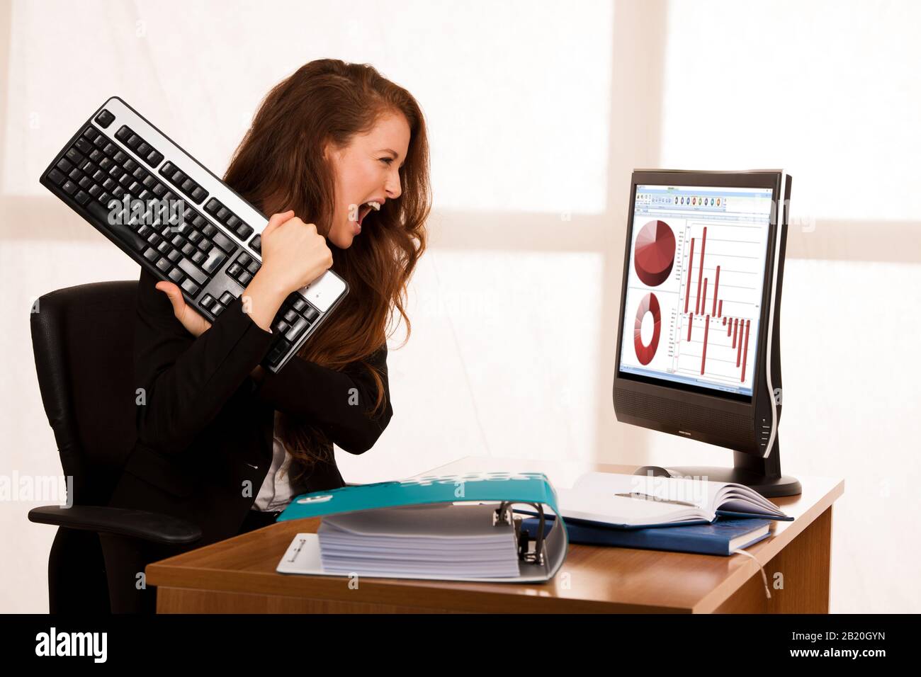 Angry business woman expressing rage at her desk in the office Stock ...