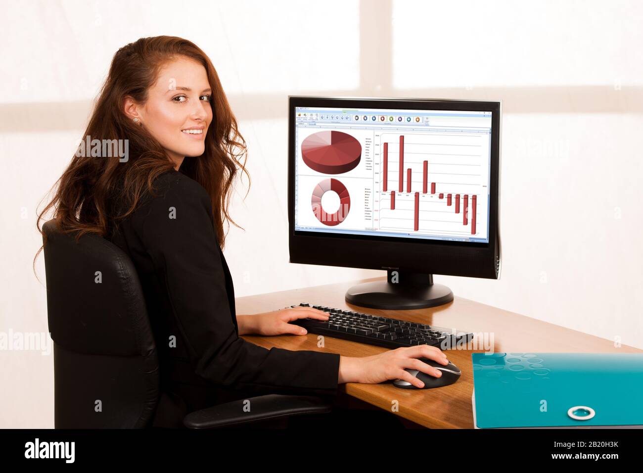 Baeutiful young business woman working at her desk in the office ...