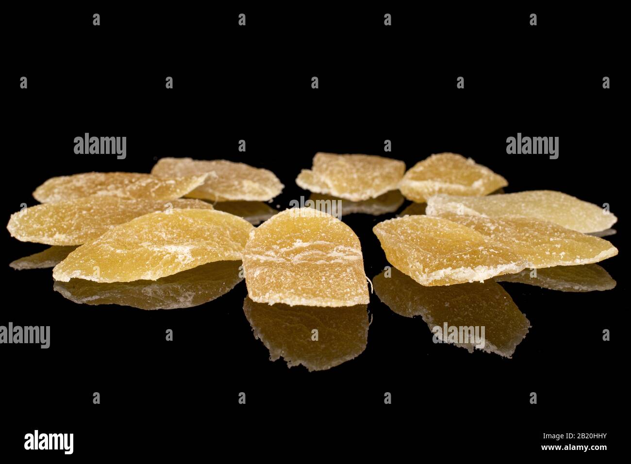 Group of nine slices of dried yellow pineapple isolated on black glass ...