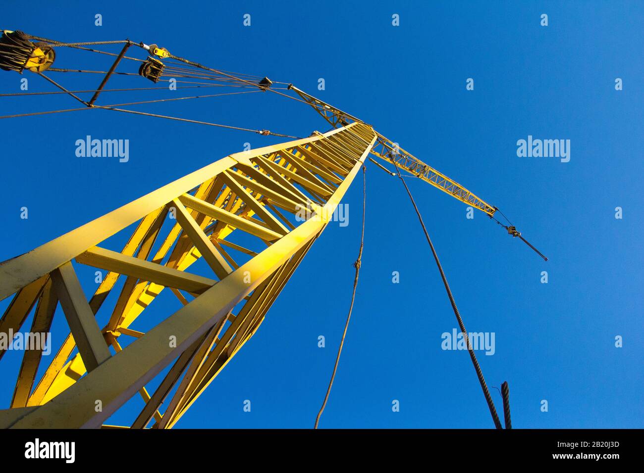 Yellow construction crane on a background of blue sky. Lifting gear ...
