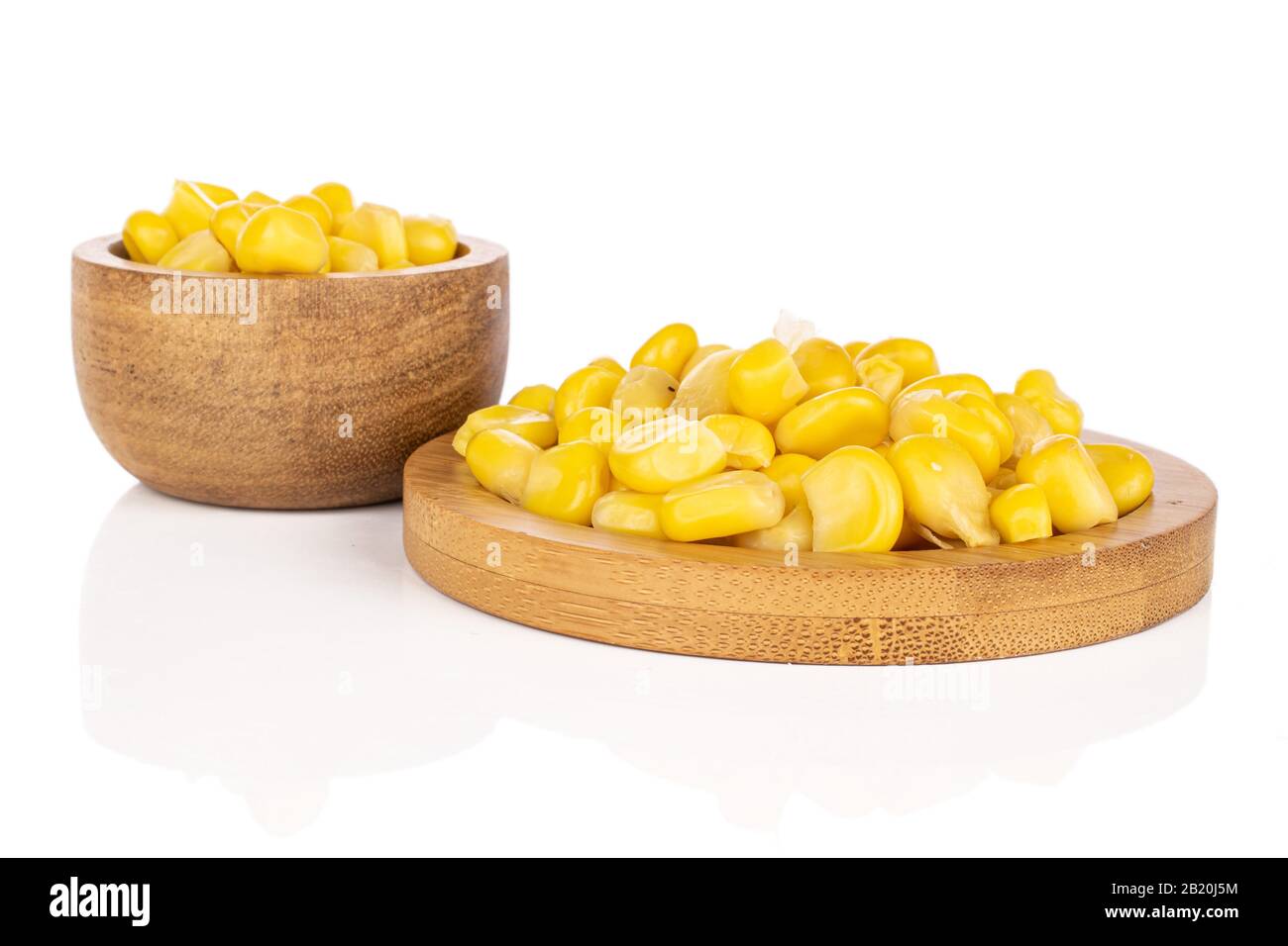 Lot of pieces of canned yellow corn on round bamboo coaster in bamboo ...